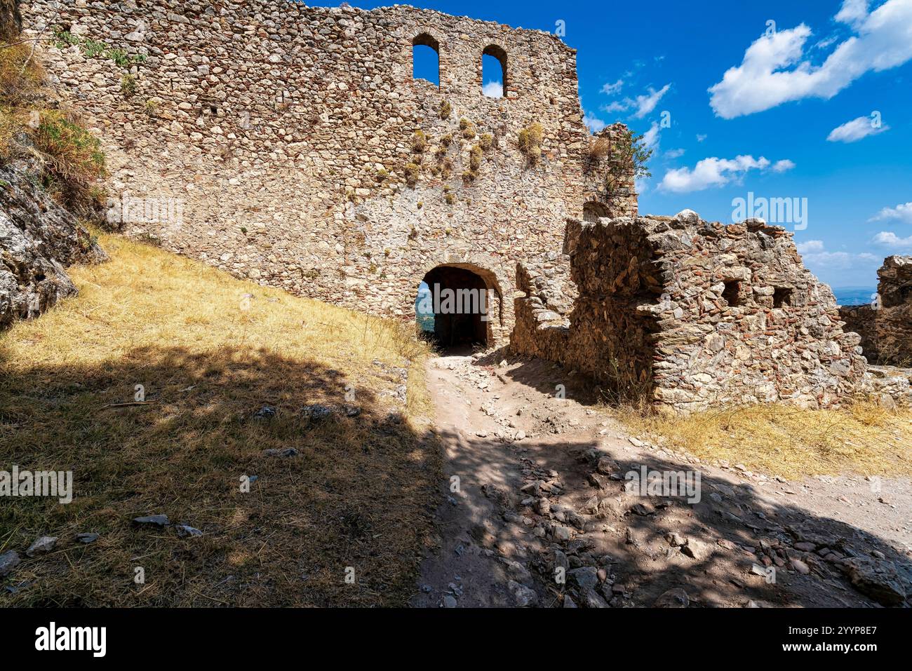 Ancient stone ruins and a sunlit archway at Mystras, Greece ...