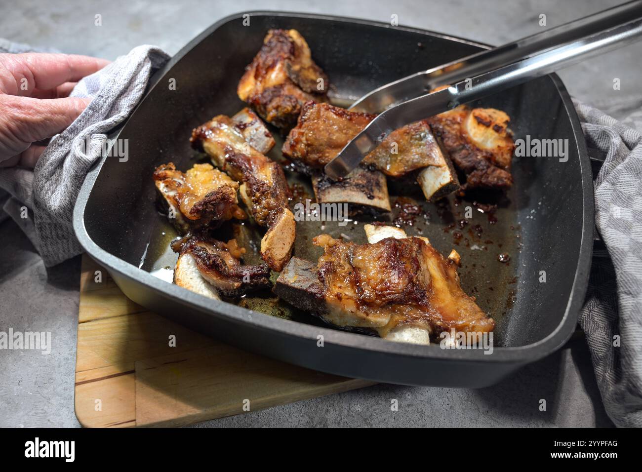 Roasting bones of veal and beef with lots of rendered fat in an oven ...