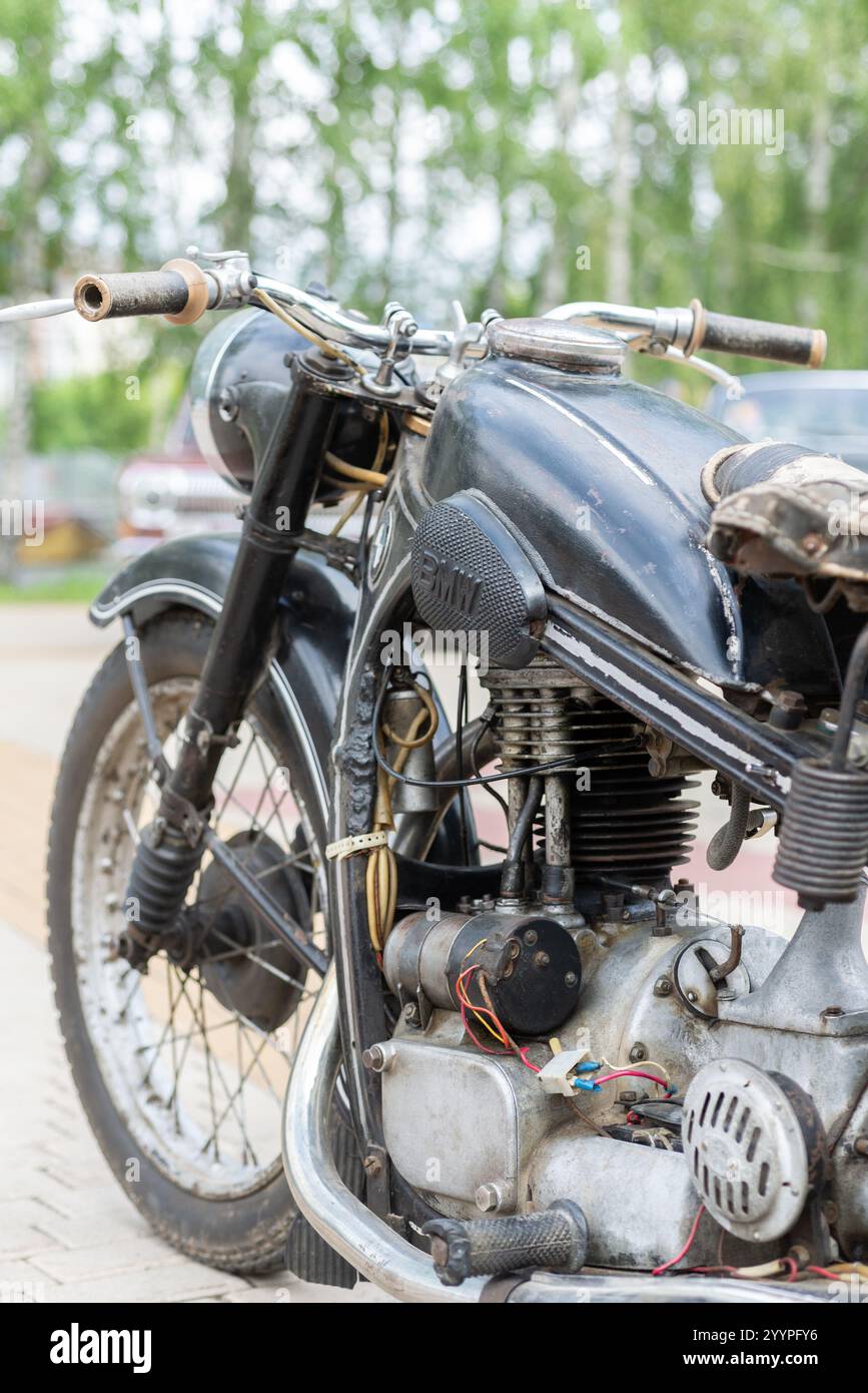 Details of an old retro motorcycle in the park. Front wheel and other ...