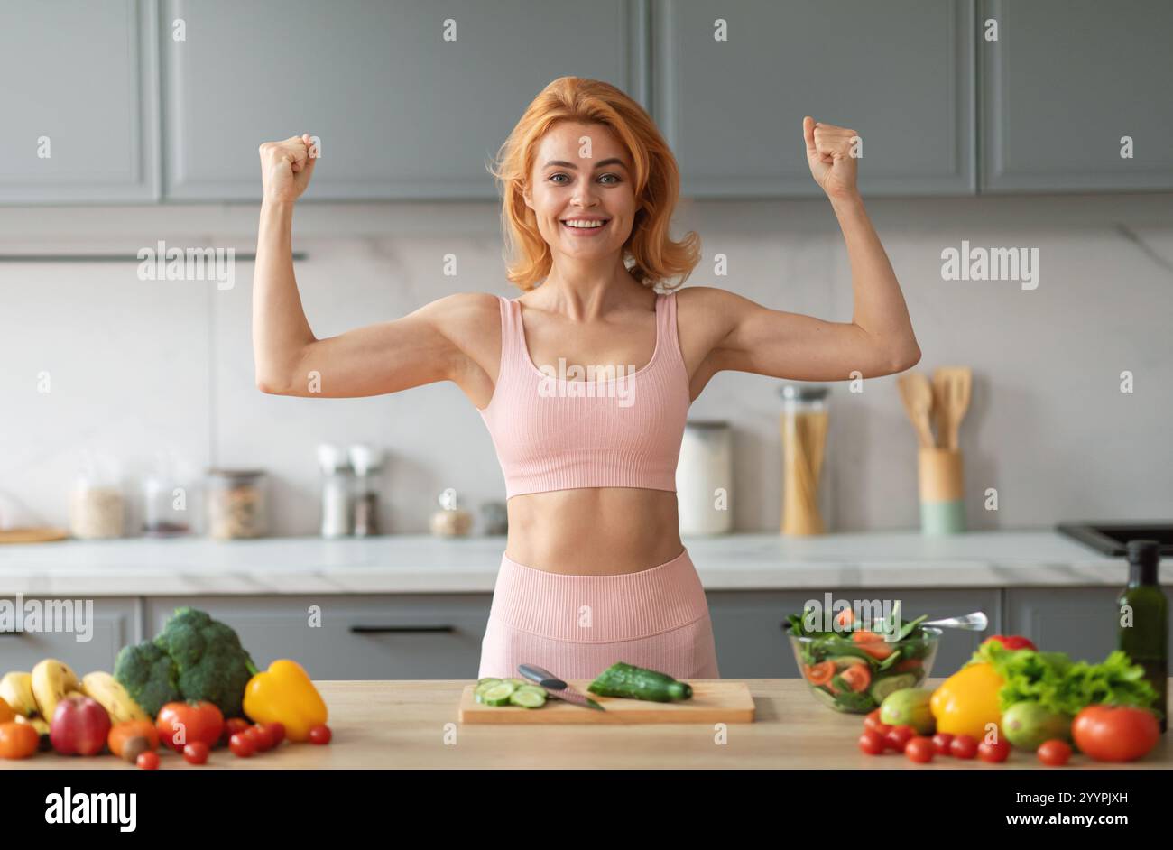 Strong woman showcasing healthy cooking skills in modern kitchen ...