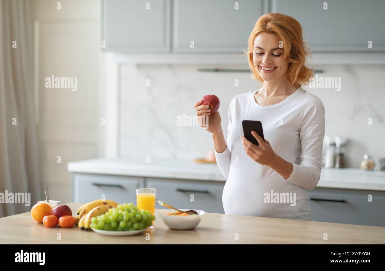 A pregnant woman enjoying healthy snacks while checking her phone in ...