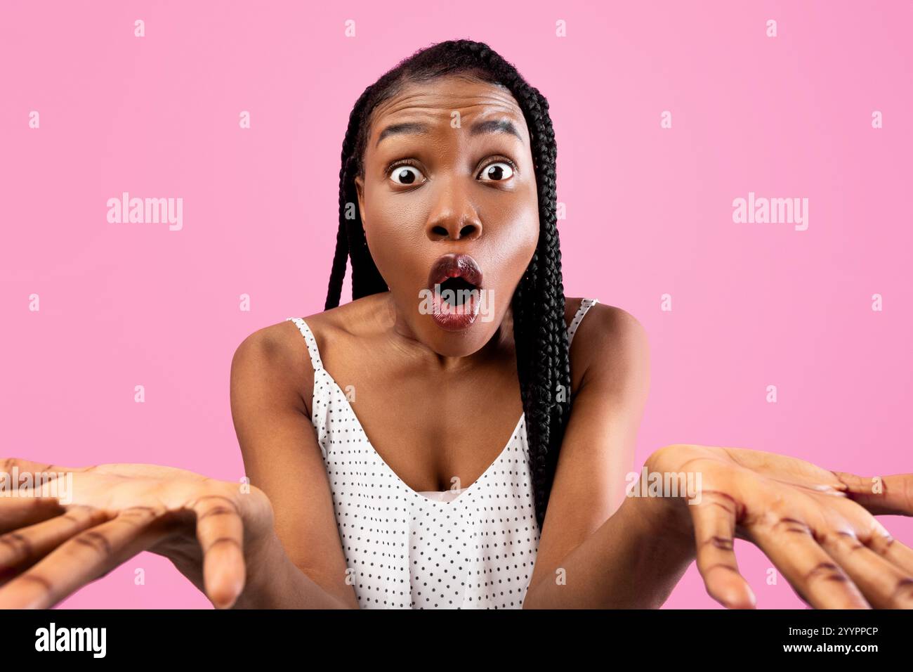 Shocked Arican American lady looking at camera, gesturing WTF over pink studio background Stock ...