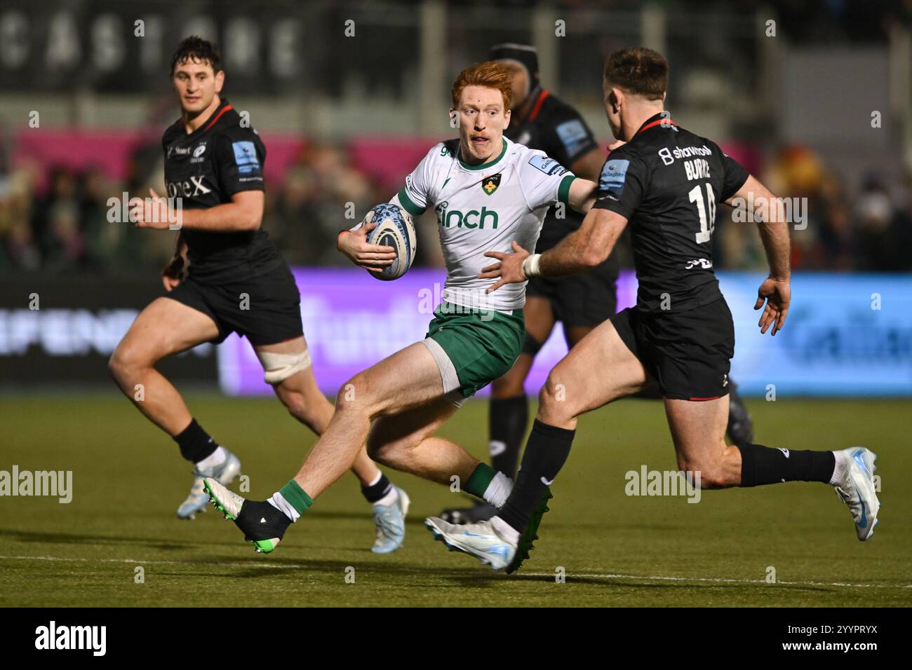 George Hendy of Northampton Saints with the ball as Fergus Burke of ...