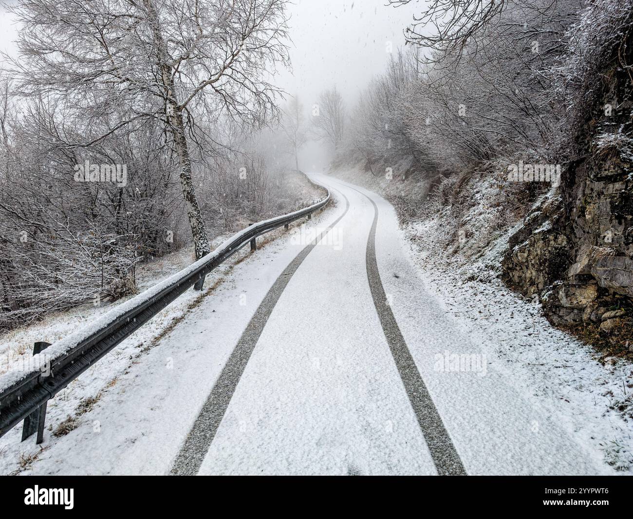 Snow on a road in winter season in the italian prealps Stock Photo - Alamy
