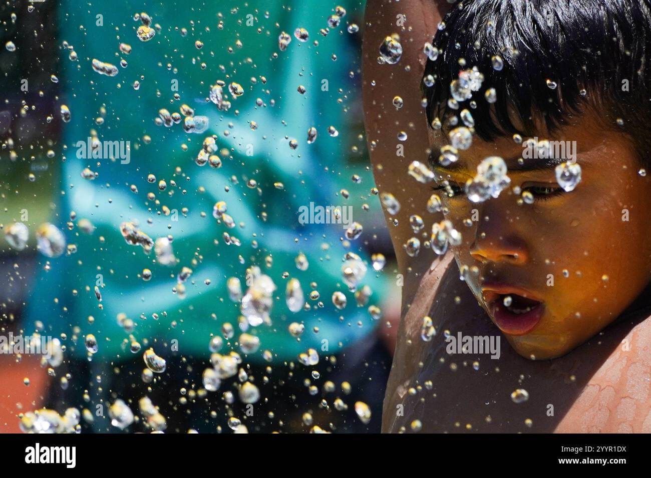 Santiago, Santiago, Chile. 22nd Dec, 2024. A boy plays with water in a ...