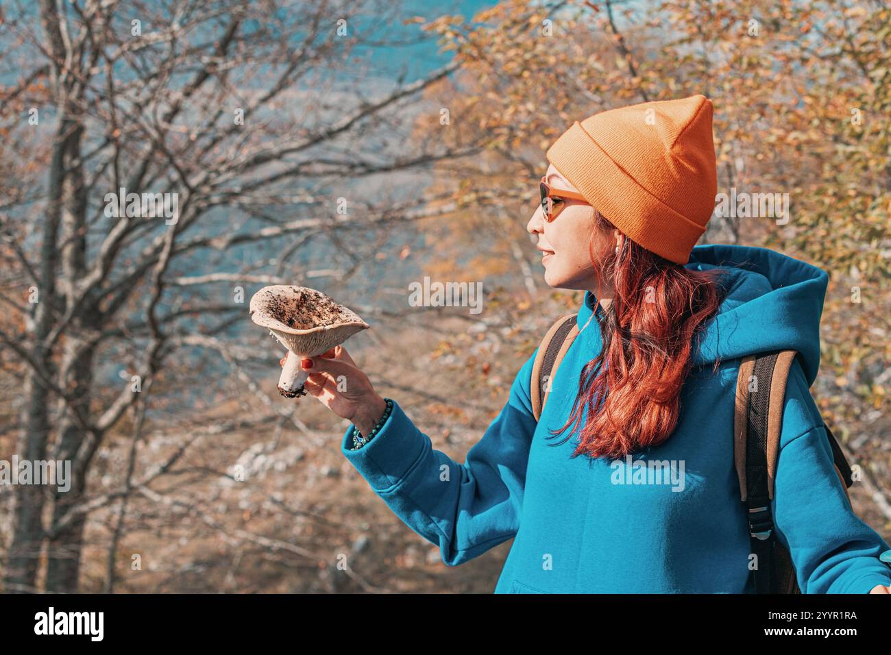 Happy forager showing freshly picked mushroom during a sunny autumn day ...