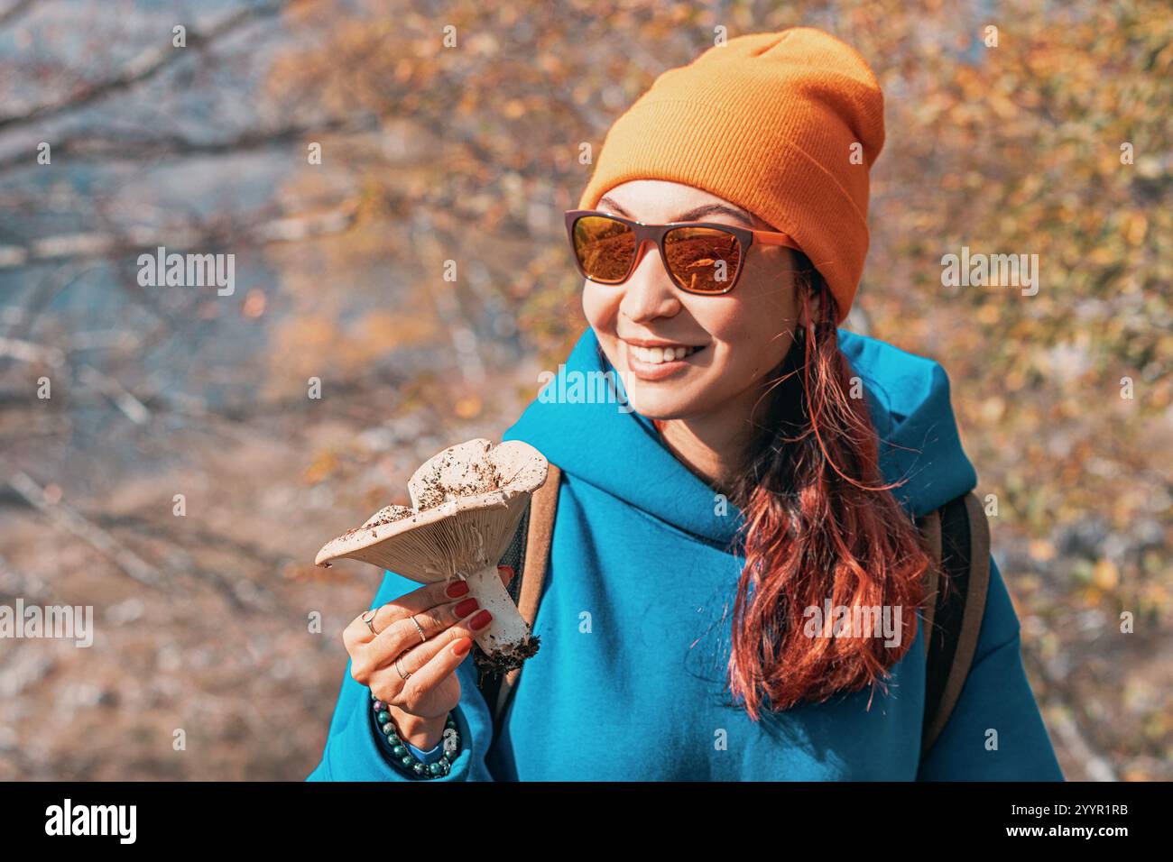 Happy forager showing freshly picked mushroom during a sunny autumn day ...