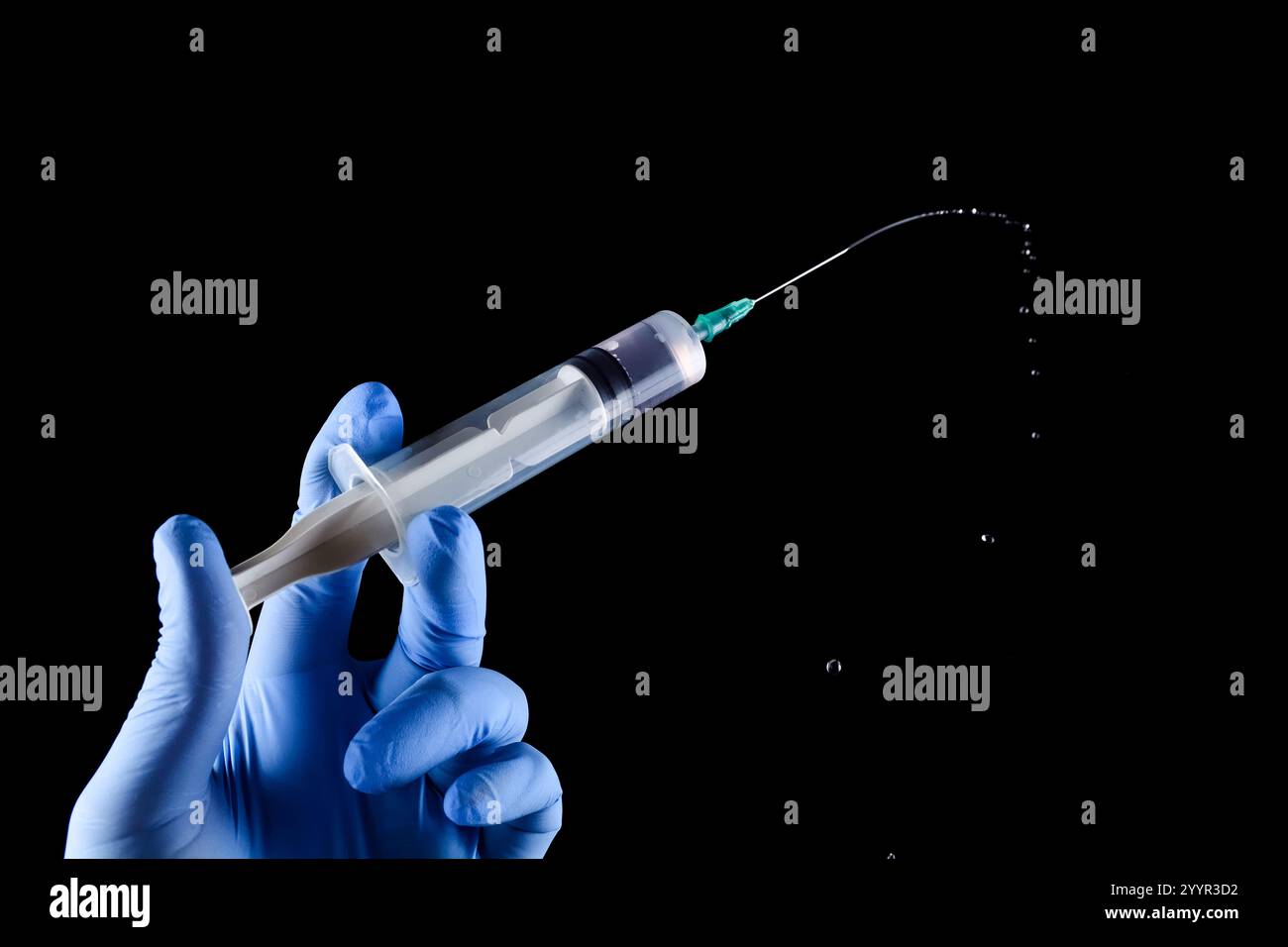 Hand in medical protective gloves holding a syringe with medication and ...