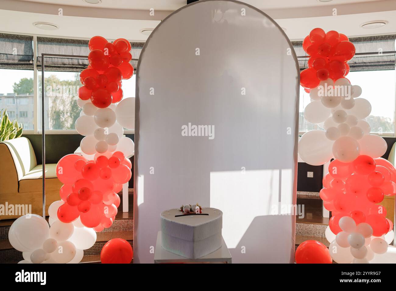 Festive Celebration Setup with Balloon Arch and White Cake Stock Photo - Alamy