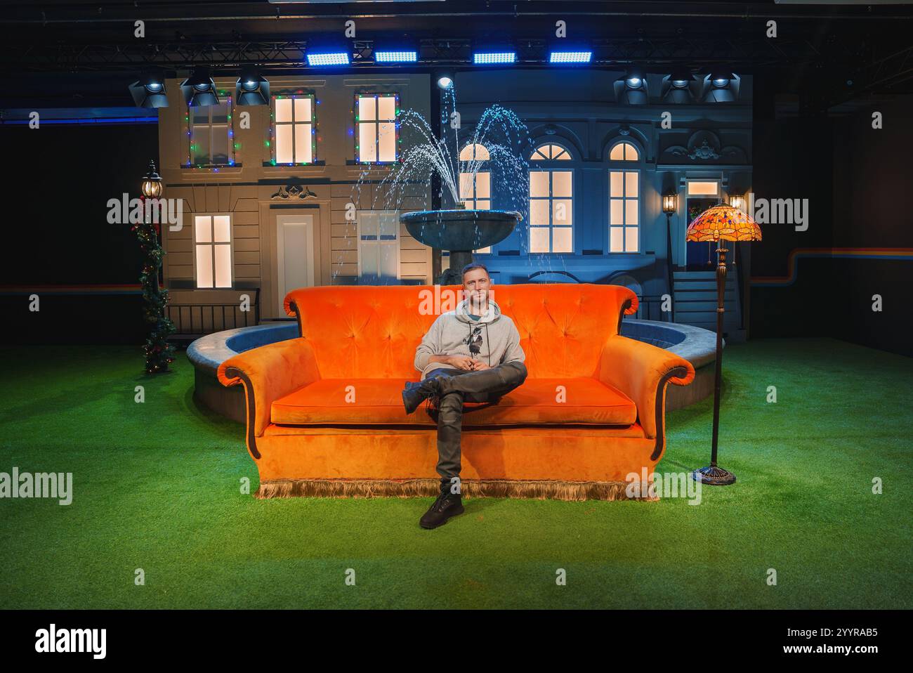 Man Seated on Iconic Orange Couch in London Themed Experience Stock ...