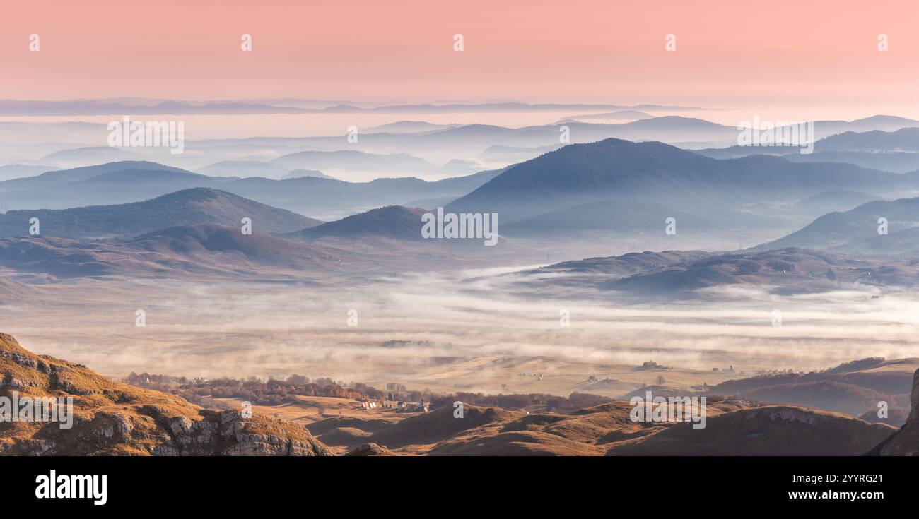 Low lying clouds and mist covering the landscape at sunrise, creating a ...
