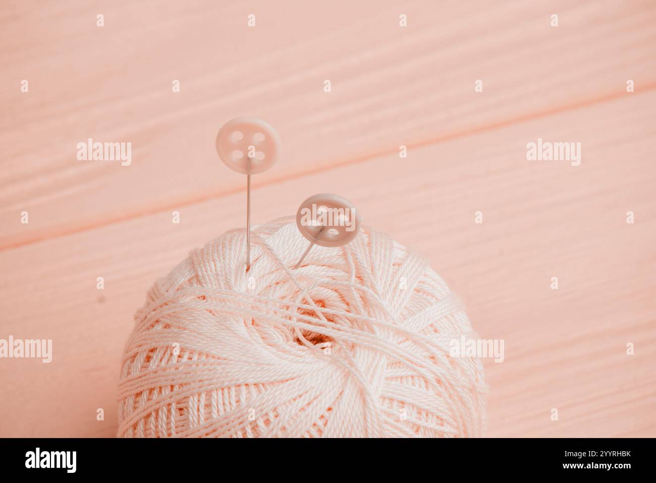 pantone palette. Pins are stuck into a soft pink skein of knitting ...