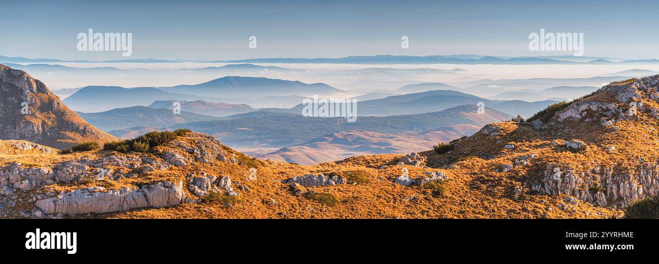 Stunning panoramic view of golden hills and mountain ridges bathed in ...
