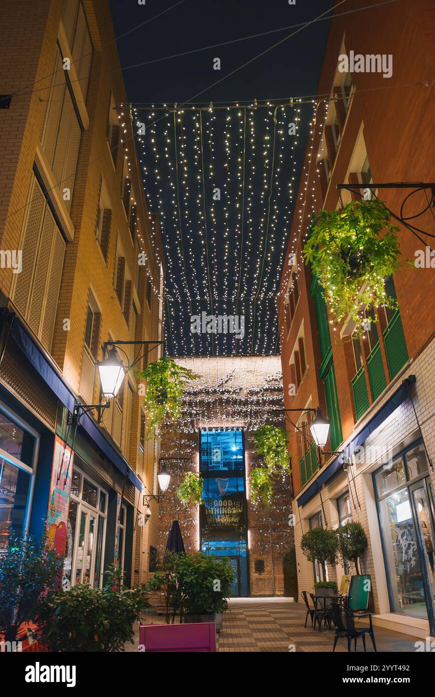 A charming London alleyway features overhead Christmas lights, warm ...