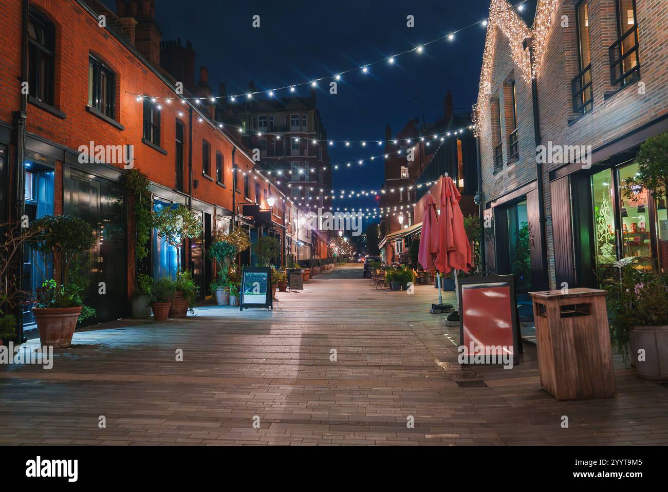 A London street is adorned with festive string lights and Christmas ...