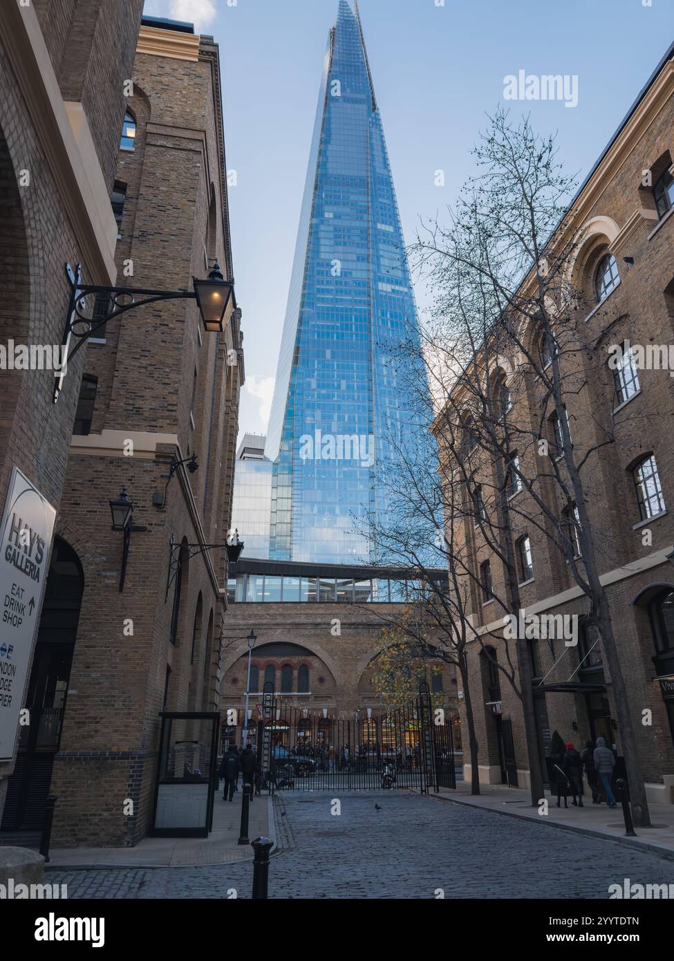 The Shard's glass facade reflects the sky, framed by historic brick ...