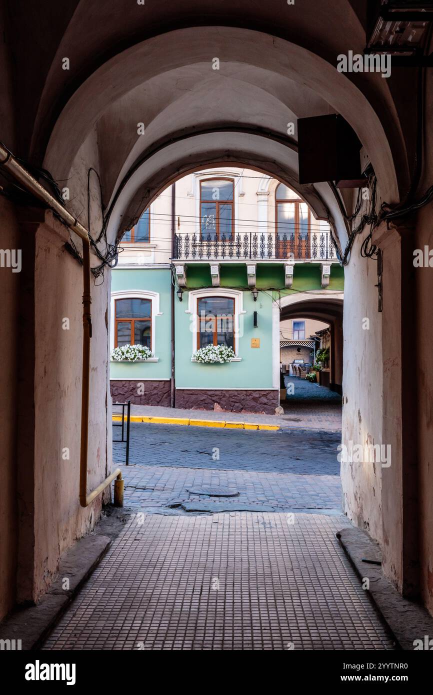 A narrow alleyway with a building on either side. The building on the ...