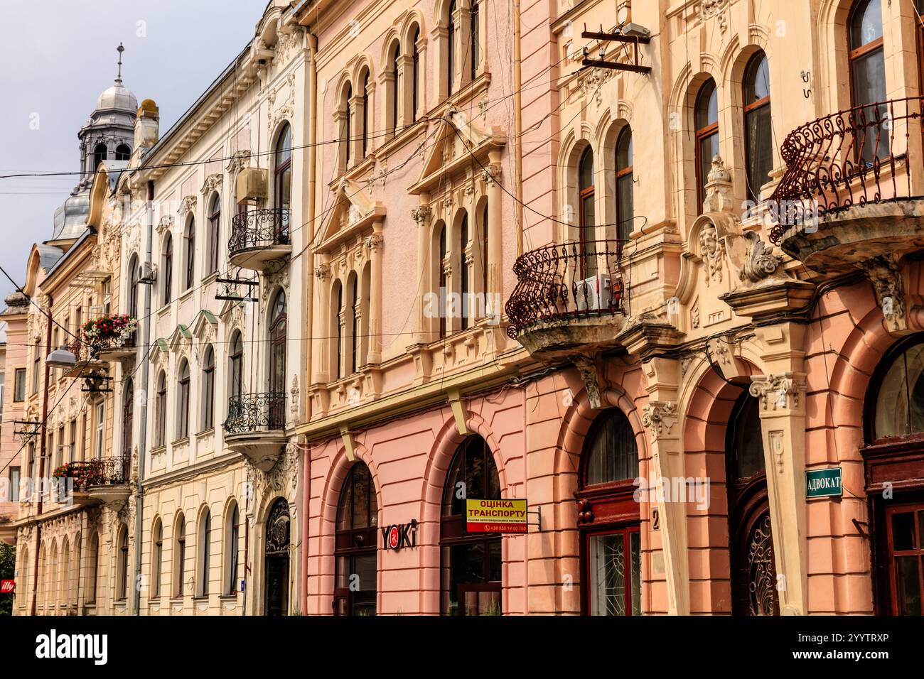 A row of buildings with a yellow sign on the front of one. The ...
