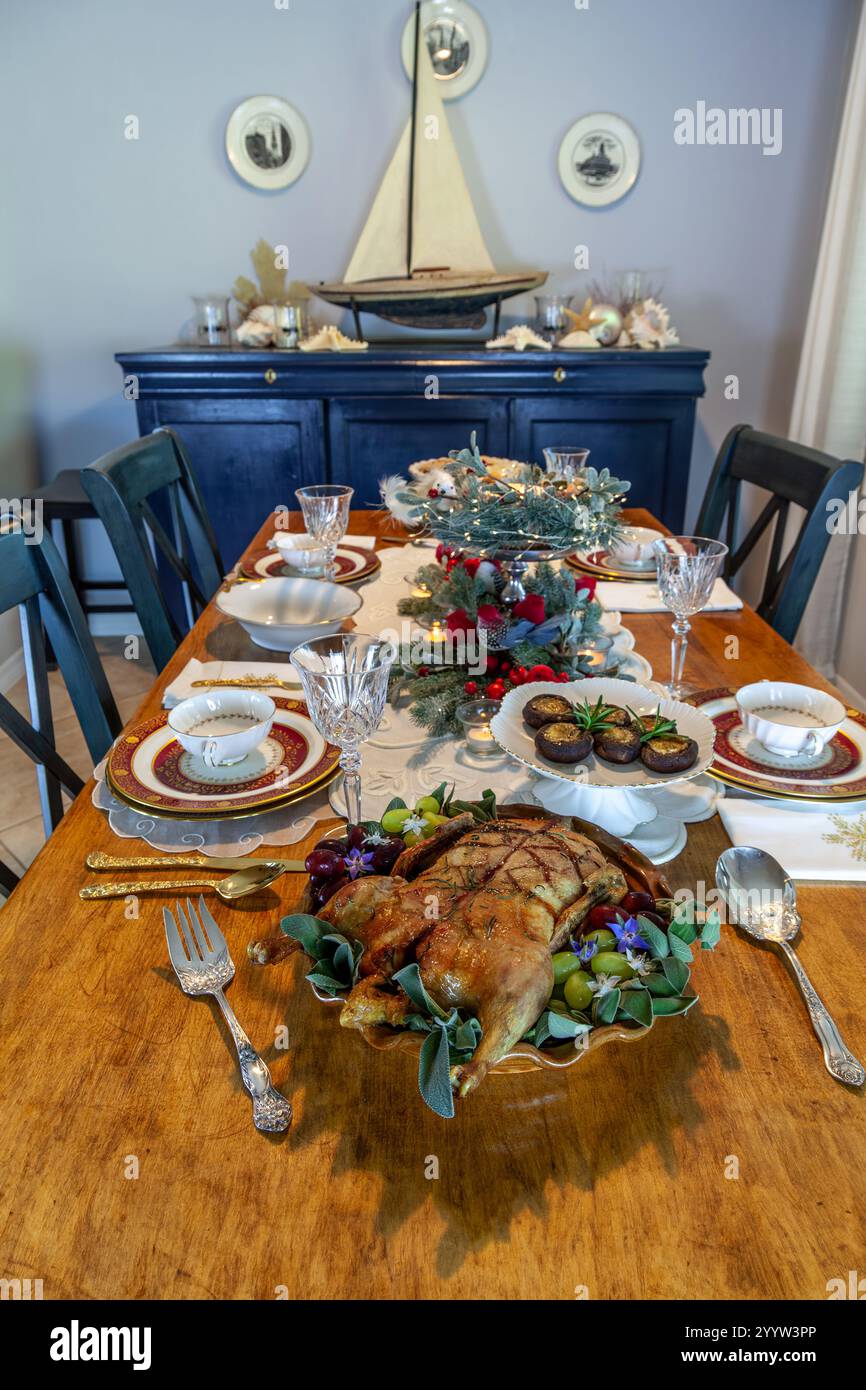 Roasted duck on a platter with sage leaves and grapes on a formal table ...