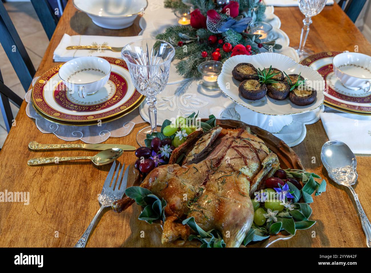 Roasted duck on a platter with sage leaves and grapes on a formal table ...