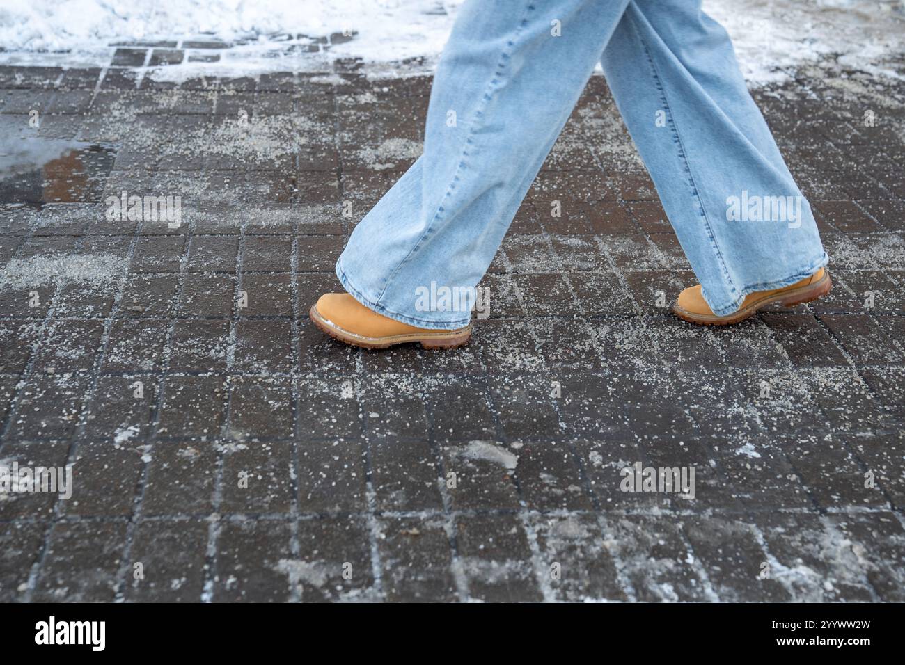 Anti-icing chemicals. Woman walking on the street treated with ...