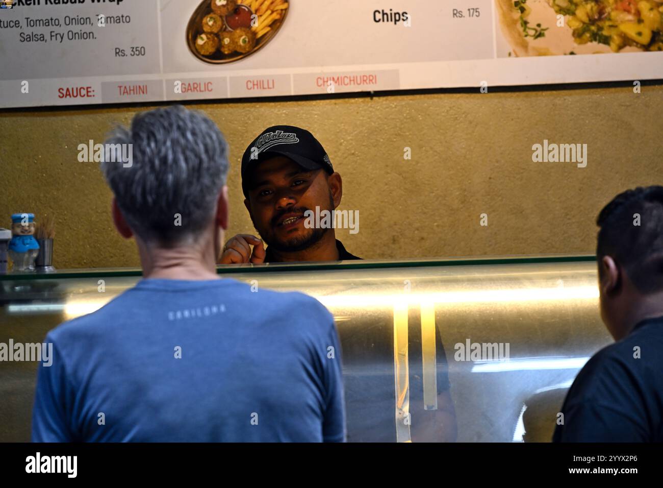 A Nepali chef serves tourists in his fast food restaurant in Thamel ...