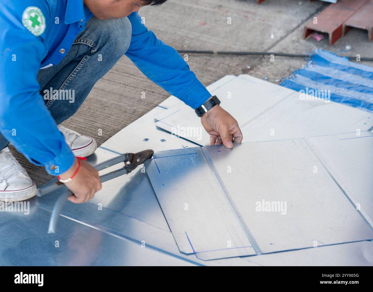 Workers use scissors to cut the metal sheet for air filter housing ...