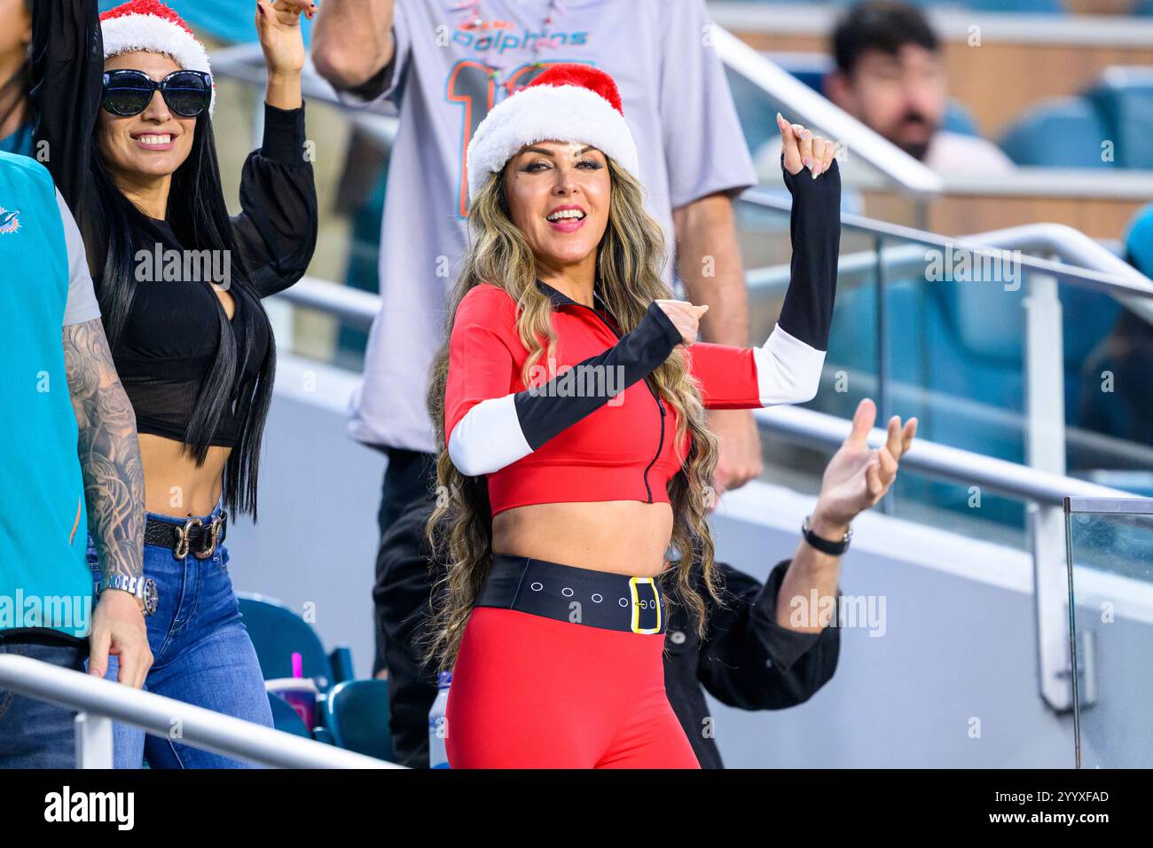 A female Miami Dolphins fan wears a Santa hat as she dances in the ...