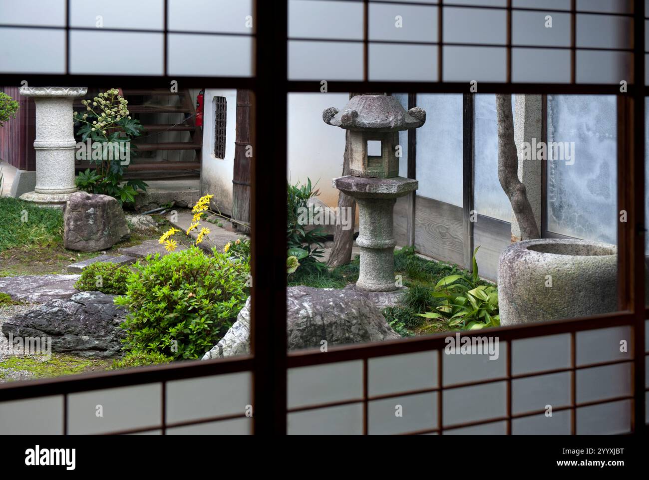 View through sliding glass shoji-like panels to a Japanese courtyard ...
