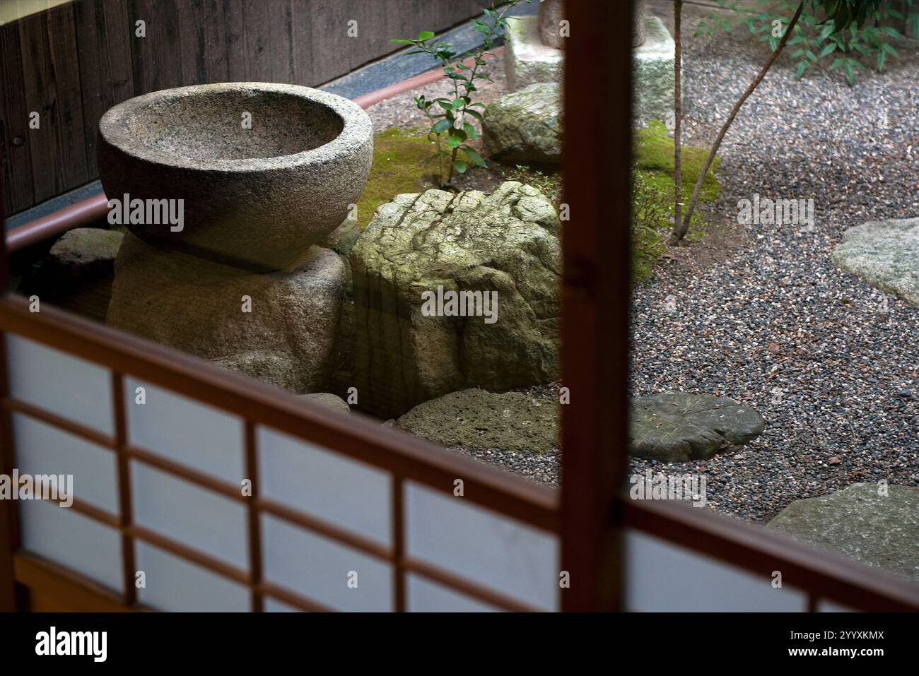 View through sliding glass shoji-like panels to a Japanese courtyard ...