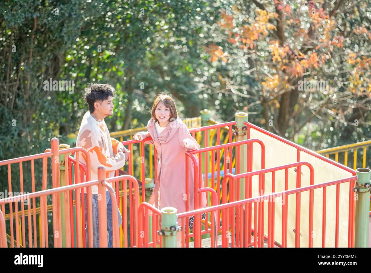 Couple in their 20s are having fun playing on playground equipment in ...