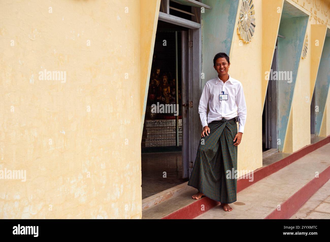 Tour guide stands in a doorway wearing traditional attire with a ...