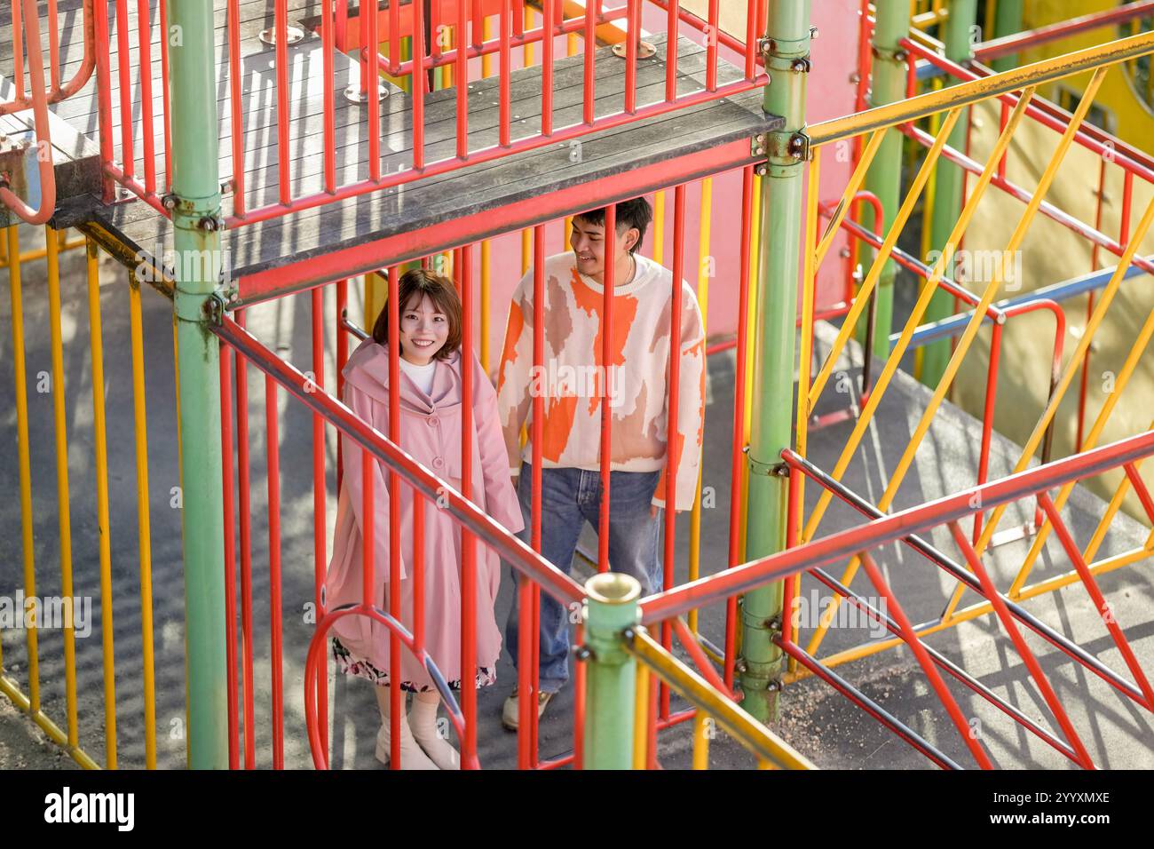 Couple in their 20s are having fun playing on playground equipment in ...
