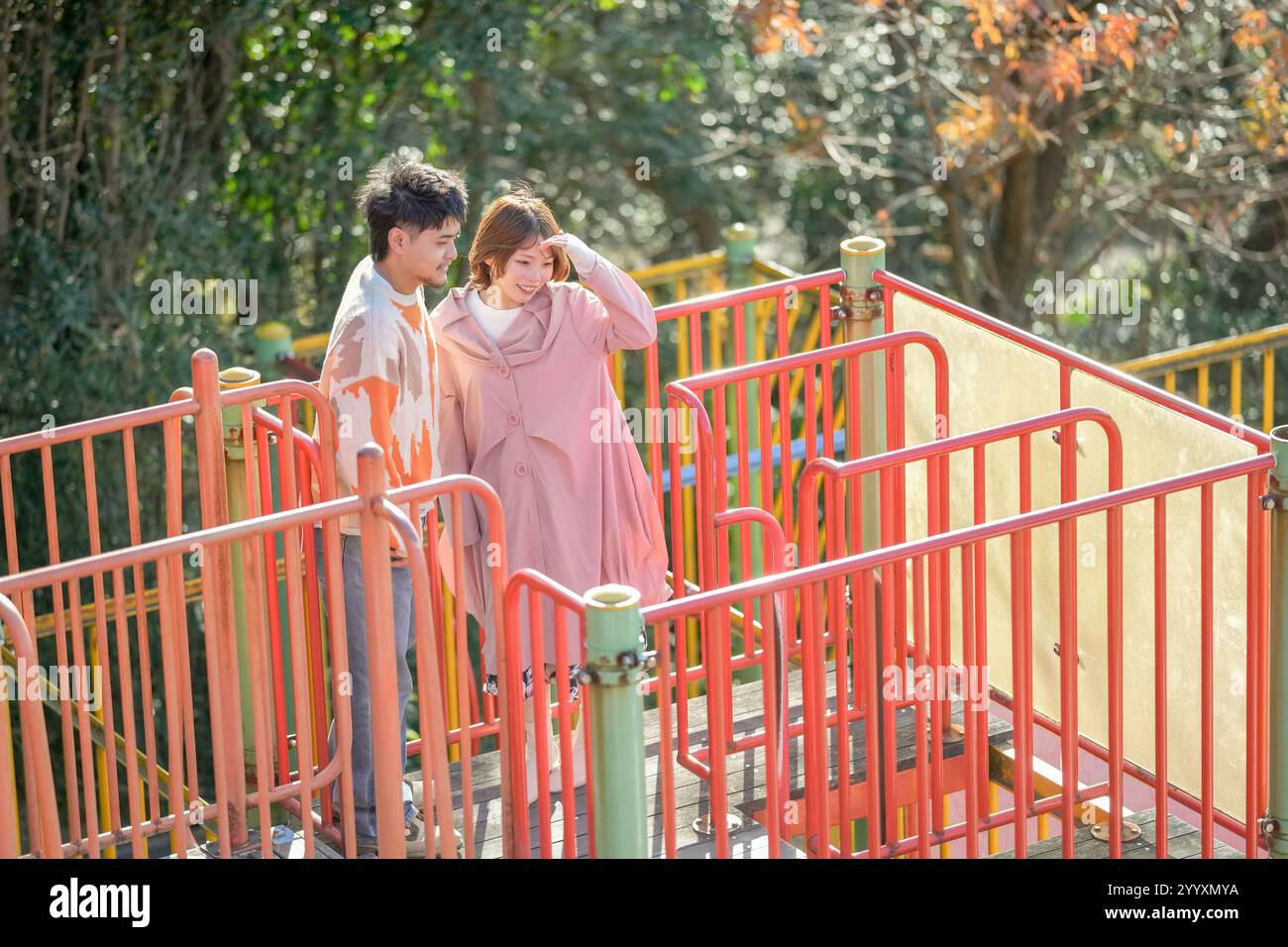 Couple in their 20s are having fun playing on playground equipment in ...