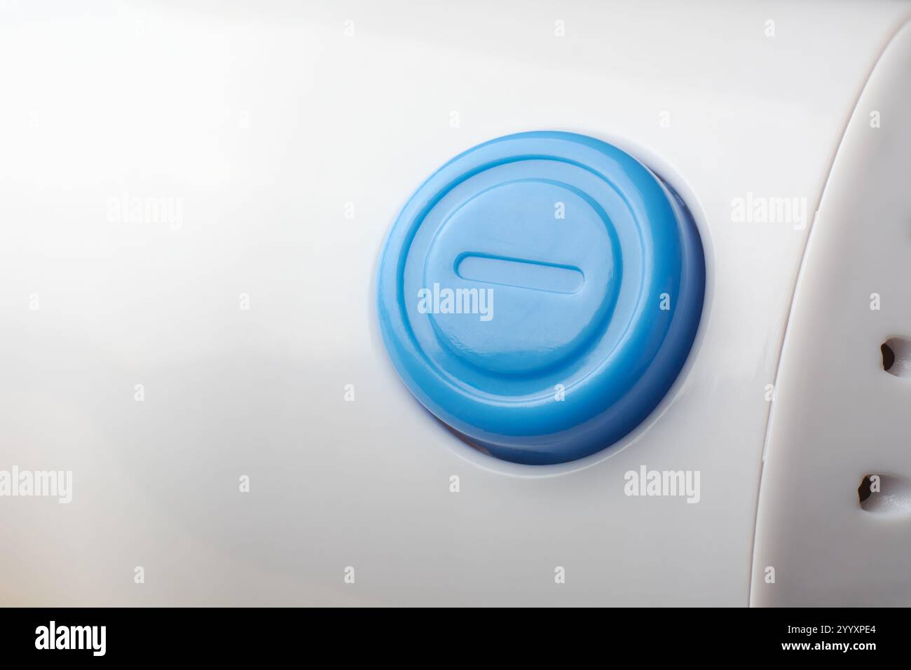 close-up of blue round button of a device or machinery on white surface ...