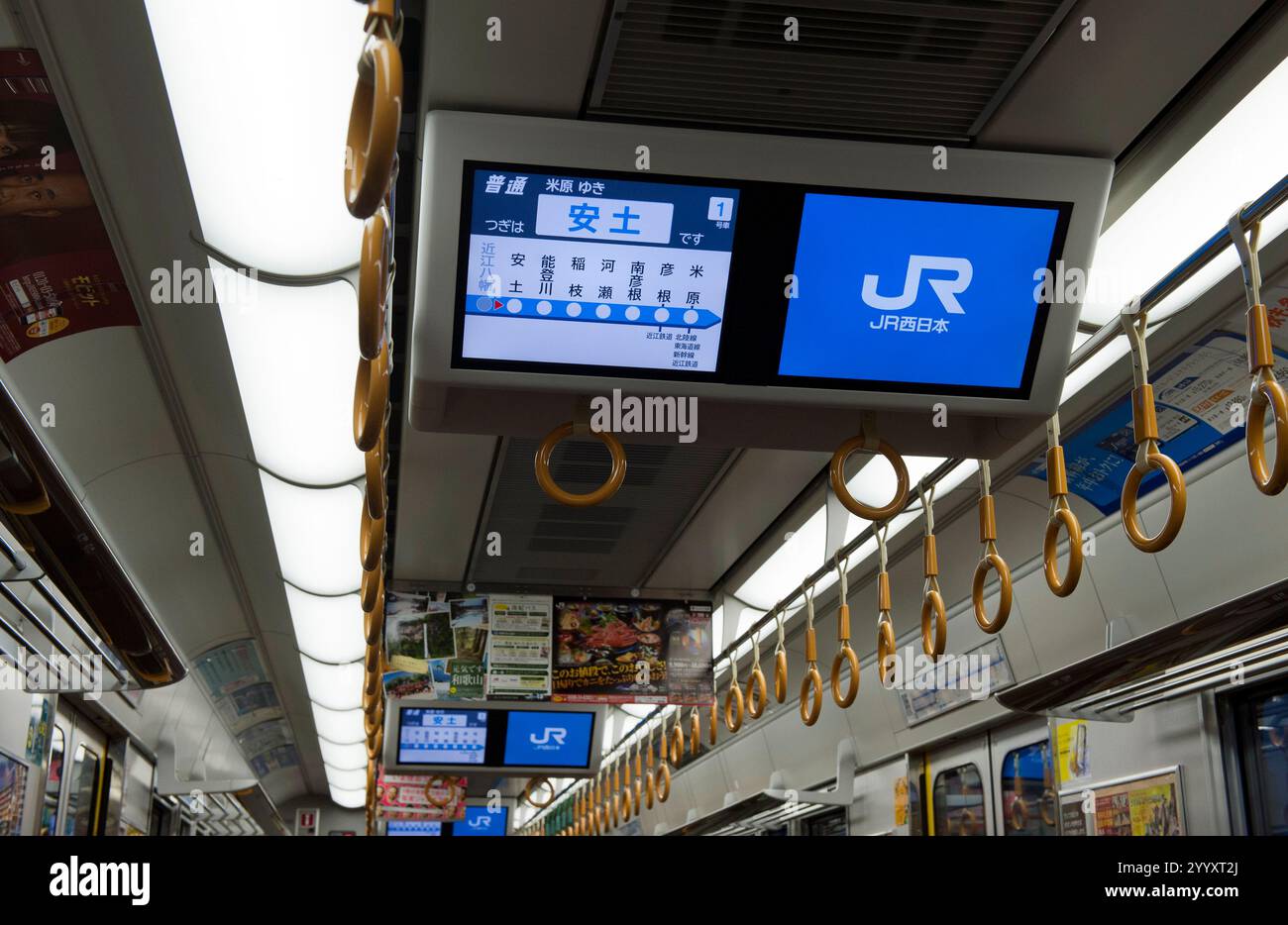 Video display monitor inside a Japan Railway (JR) train car showing the next stops along the ...