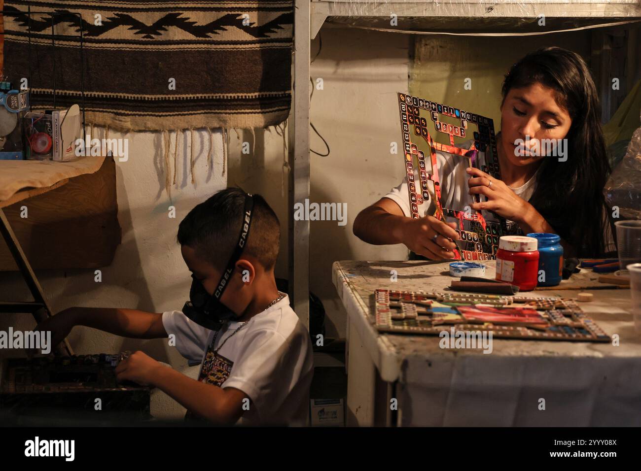 Dana Lopez, right, paints a board for poleana, a board game invented in ...