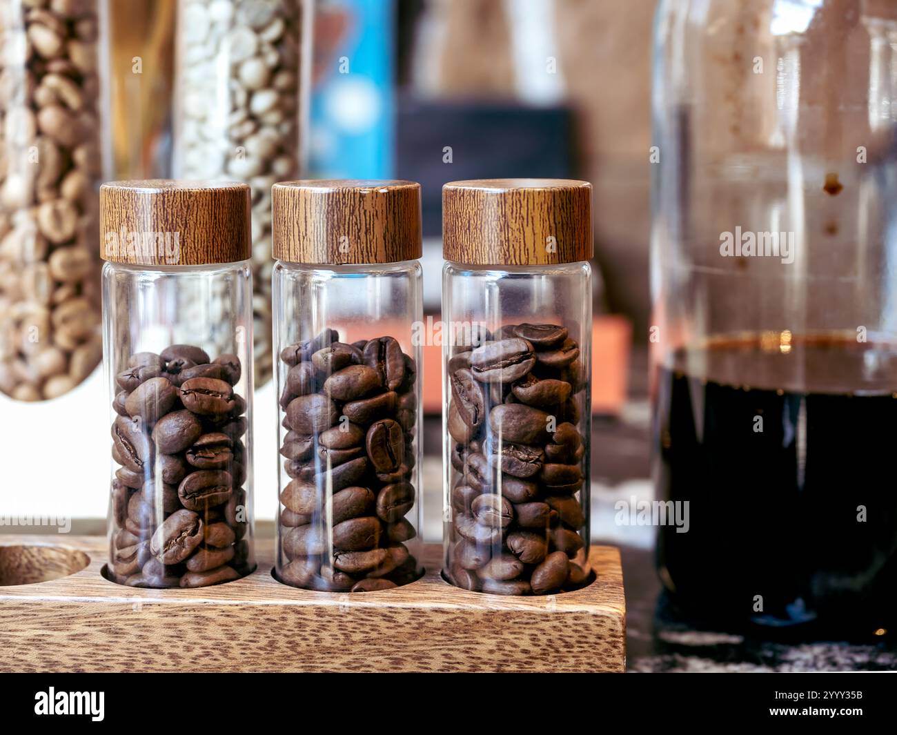 Close-up coffee beans in three glass tubes near coffee glass bottle ...