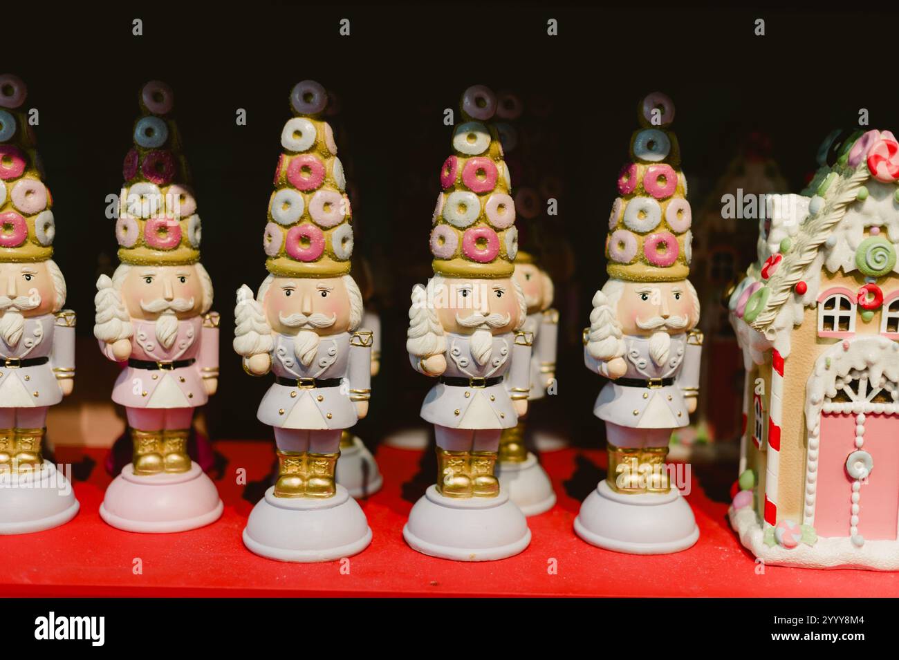 A row of nutcrackers are lined up on a red background. The nutcrackers ...