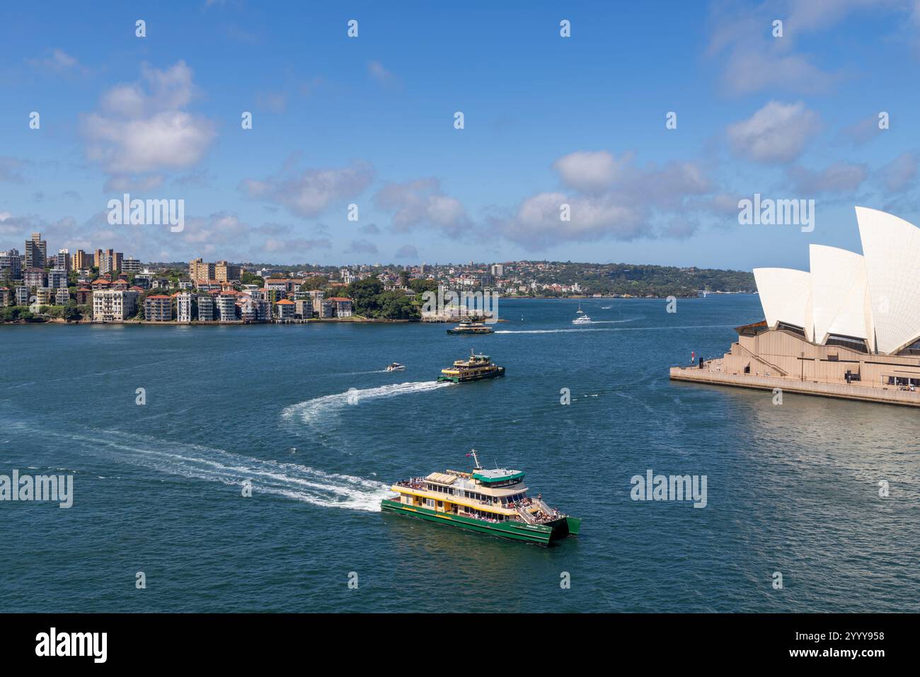 Sydney Opera House and harbour ferry from elevated viewpoint, blue sky ...