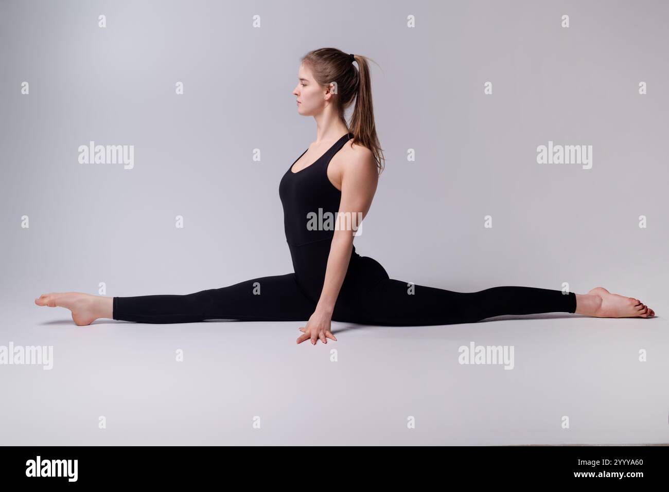 Fitness woman leg split. Woman stretching leg. Young fit slim woman is doing stretch legs. Girl ...