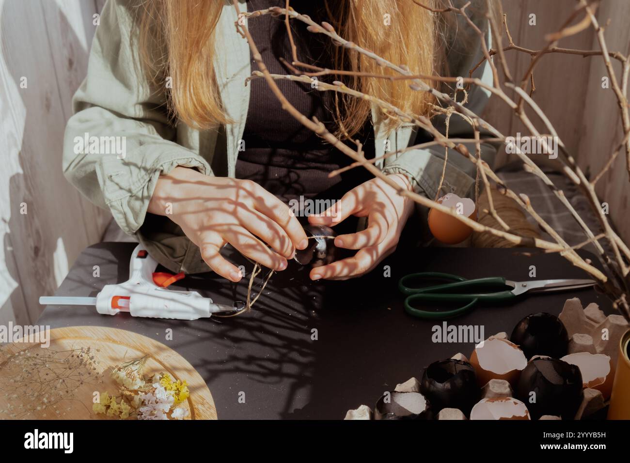 Unrecognizable woman creating Easter holiday decoration from egg shell ...