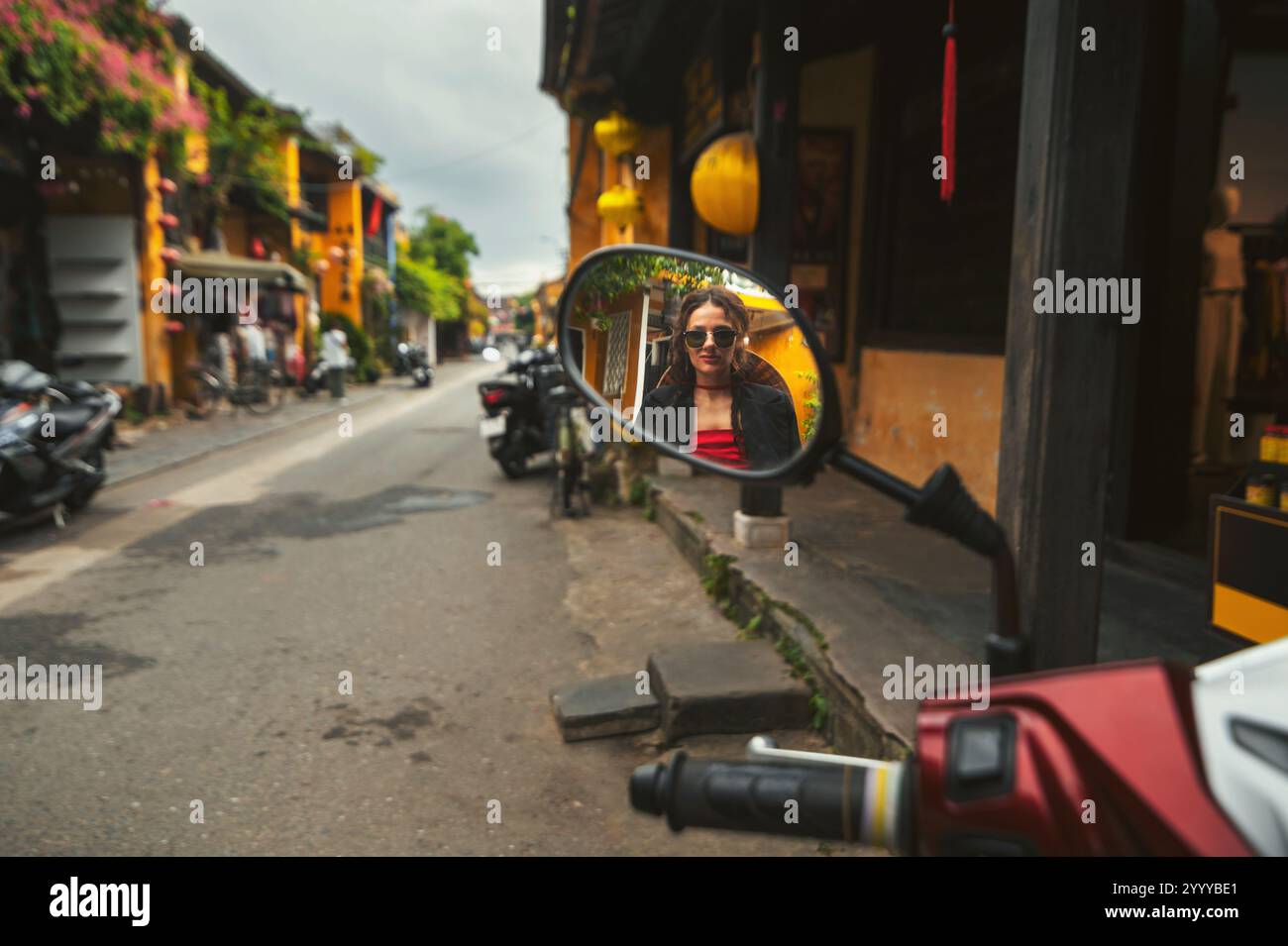 Portrait of a tourist through a motorcycle mirror wearing a Non La ...