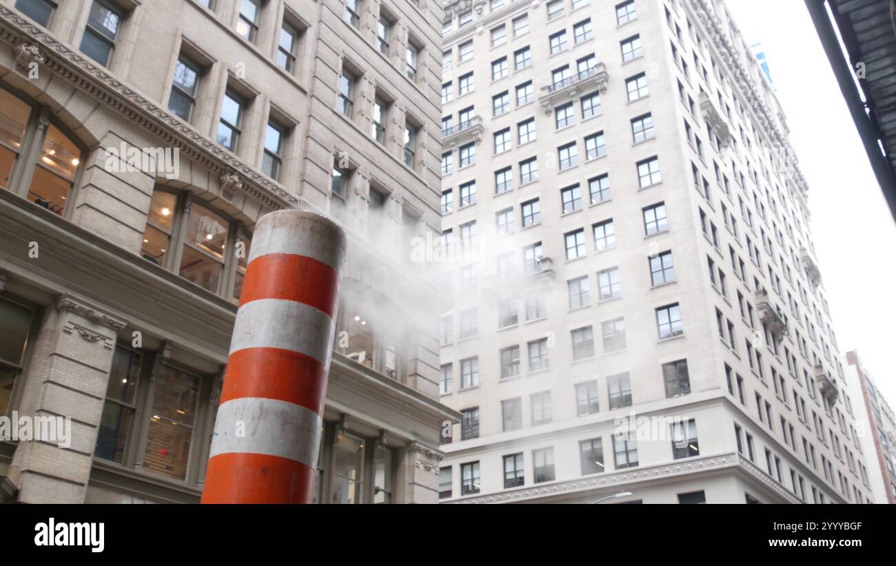 Steam vapor vented on New York City street, orange vapour tube stack ...