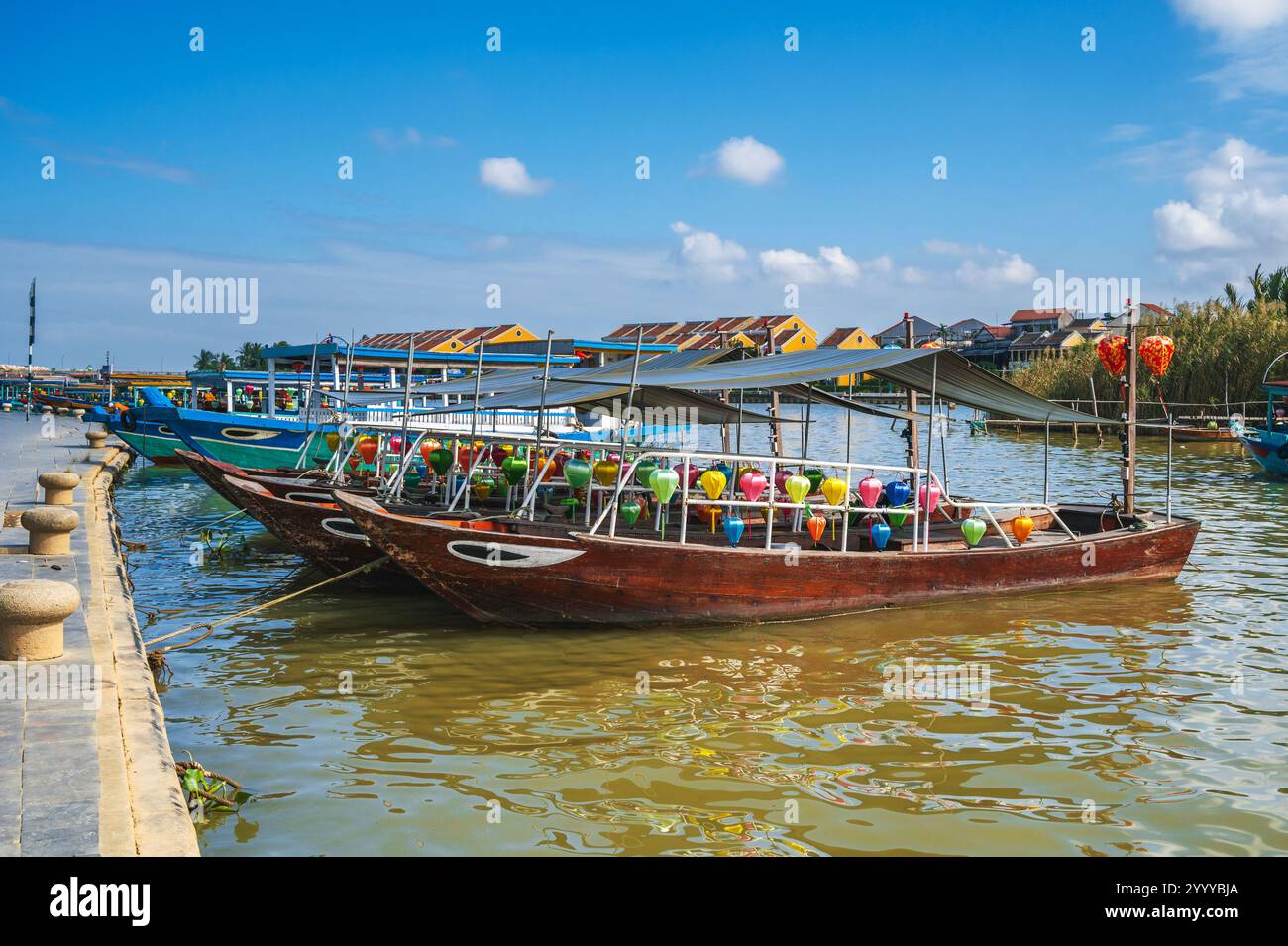 Colorful traditional Vietnamese boats decorated with lanterns lined up ...