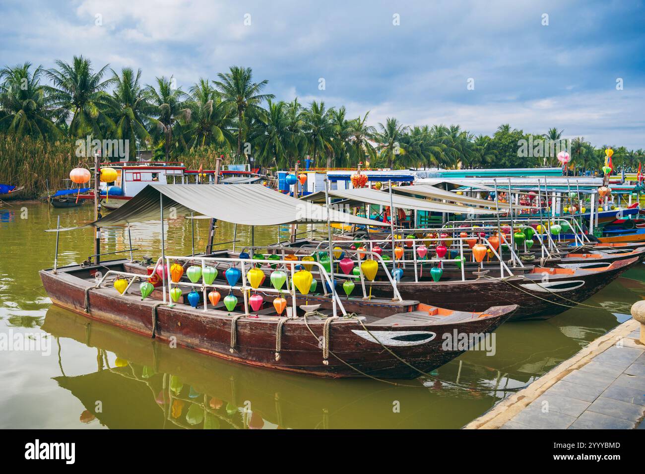 Colorful traditional Vietnamese boats decorated with lanterns lined up ...