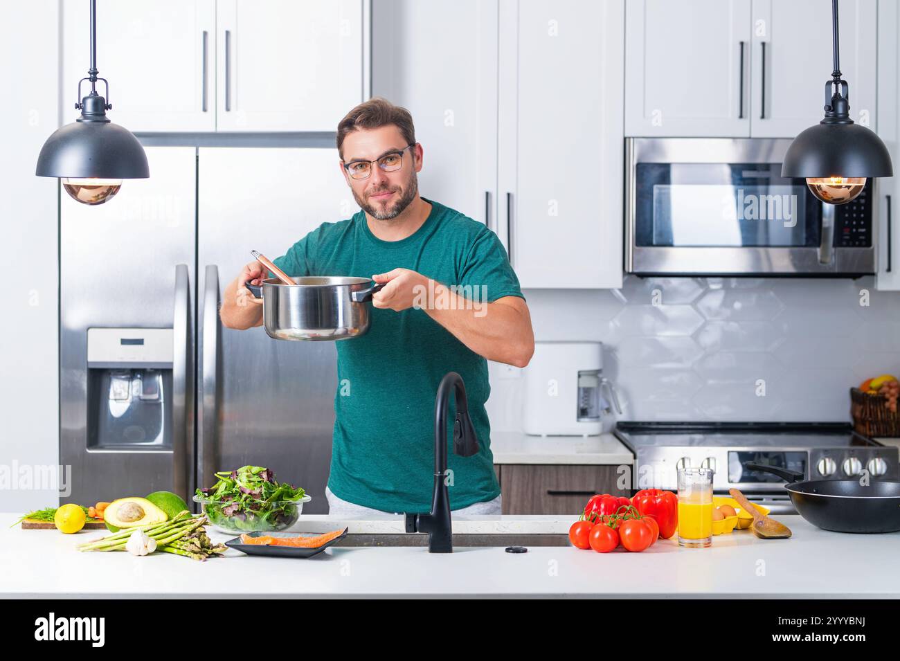 Male cook or chef cooking food in pan pot in kitchen. Process of ...