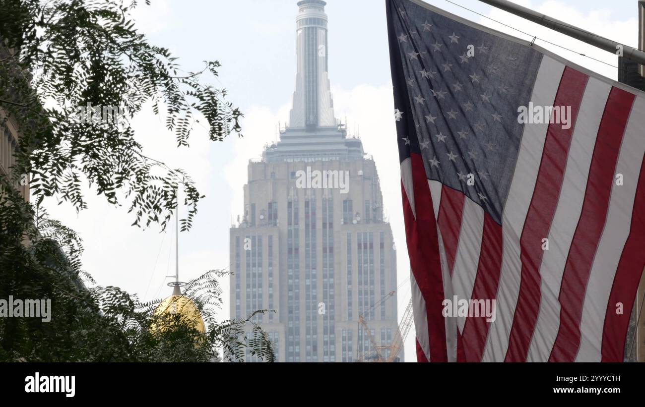 New York, american flag waving. Empire State Building. Manhattan ...