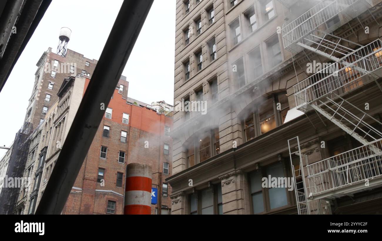 Steam vapor vented on New York City street, orange vapour tube stack ...