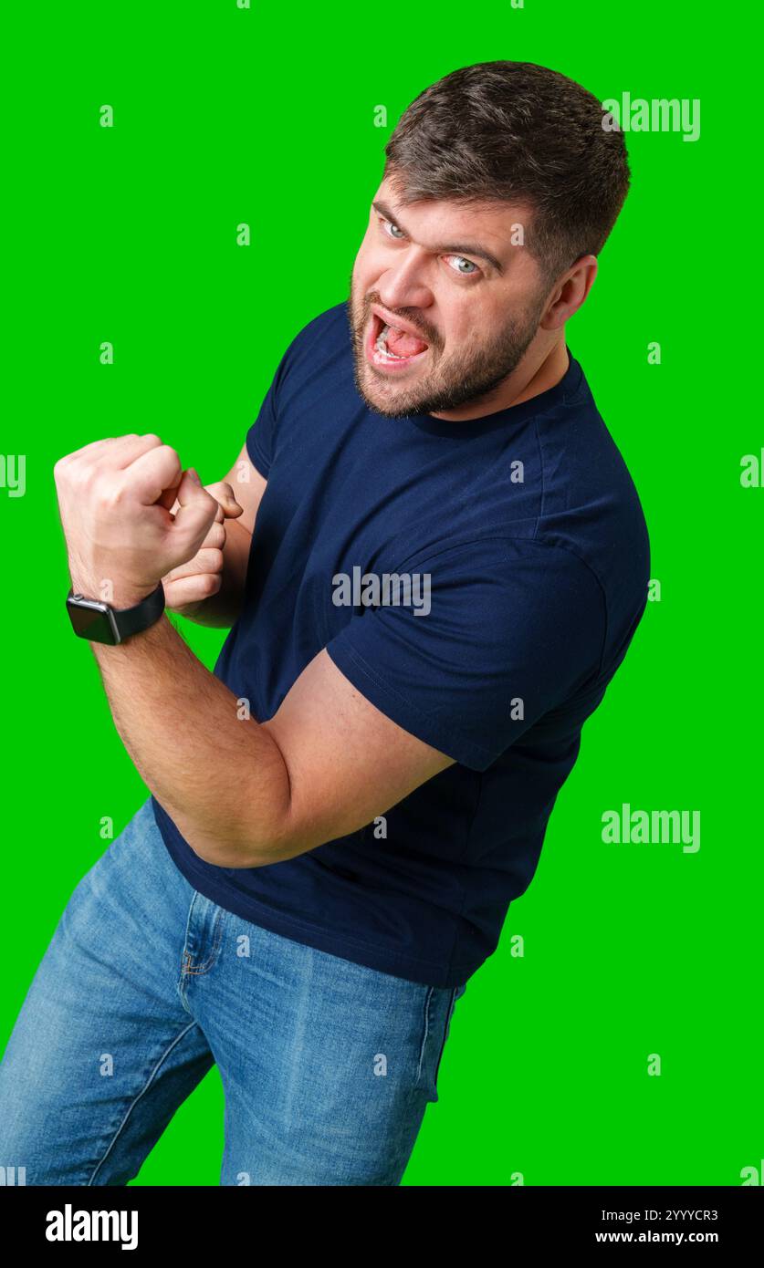 A strong man with fists raised, smiling confidently, on a bright green ...